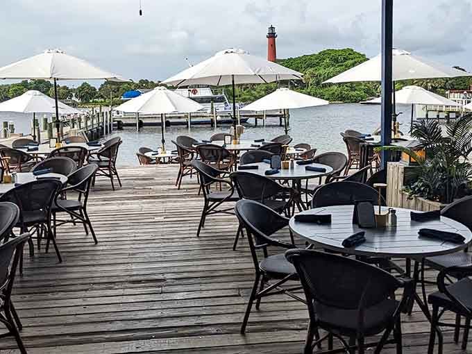 Al fresco tables on the deck with the Jupiter Lighthouse visible across the water in distance.