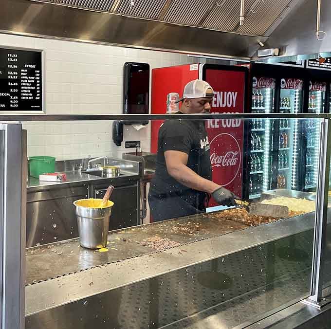 The griddle master at work, conducting a symphony of sizzling beef that would make any conductor jealous of his spatula.