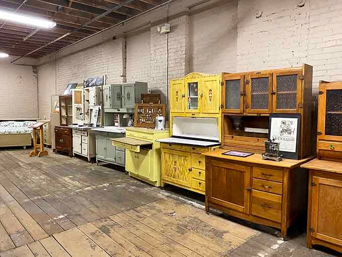 Rows of vintage Hoosier cabinets showcase the craftsmanship that made these kitchen workhorses essential before modern conveniences took over our lives completely.