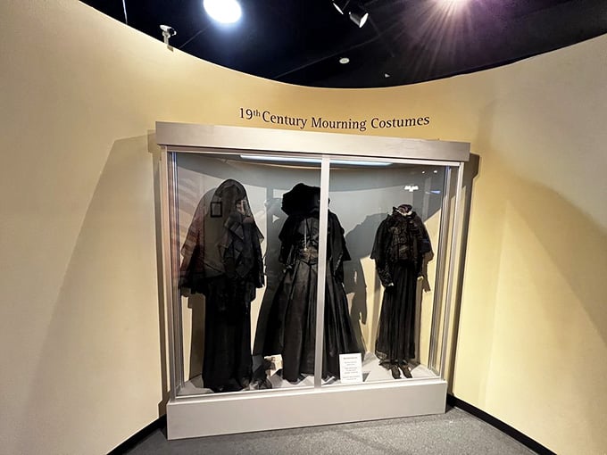 Black silk and elaborate veils showcase the strict Victorian mourning dress codes that governed grief for years.