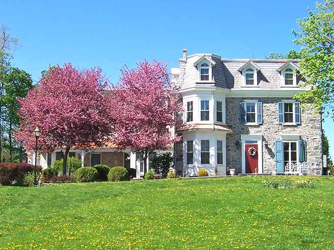 Pink blossoms frame this stone mansion like nature decided to add its own decorative touch to perfection.