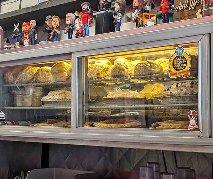 Fresh pies lined up behind glass like edible treasures, waiting to make someone's day infinitely better with every slice.