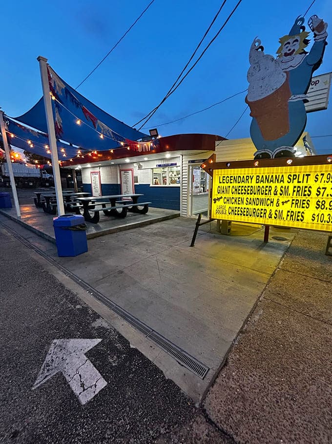 As twilight falls, string lights transform this humble spot into something magical. The legendary banana split sign glows like a beacon of sweet promises.