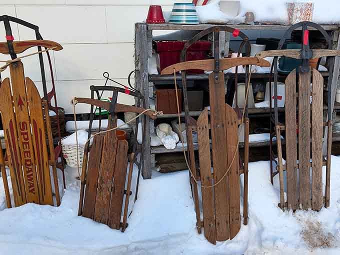 Vintage wooden sleds leaning in the snow, waiting for winter warriors who appreciate classic downhill transportation with authentic splinters.