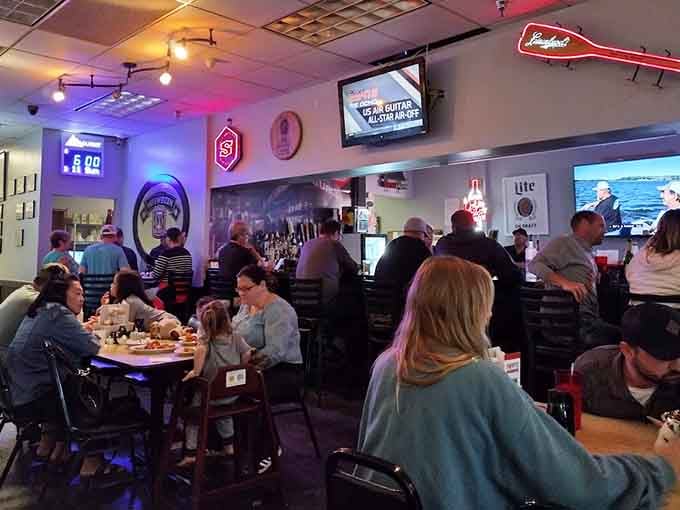 The bar area buzzes with energy as locals gather for food, drinks, and the camaraderie that makes dining memorable.