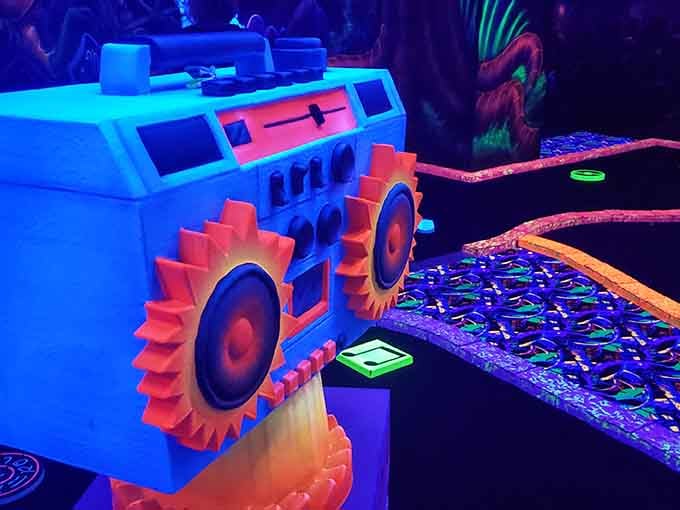 A neon boombox obstacle challenges your shot while reminding you when music required actual shoulder strength to transport.