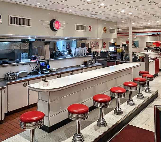 Chrome counter stools lined up like soldiers, offering front-row seats to the greatest show on earth: lunch.