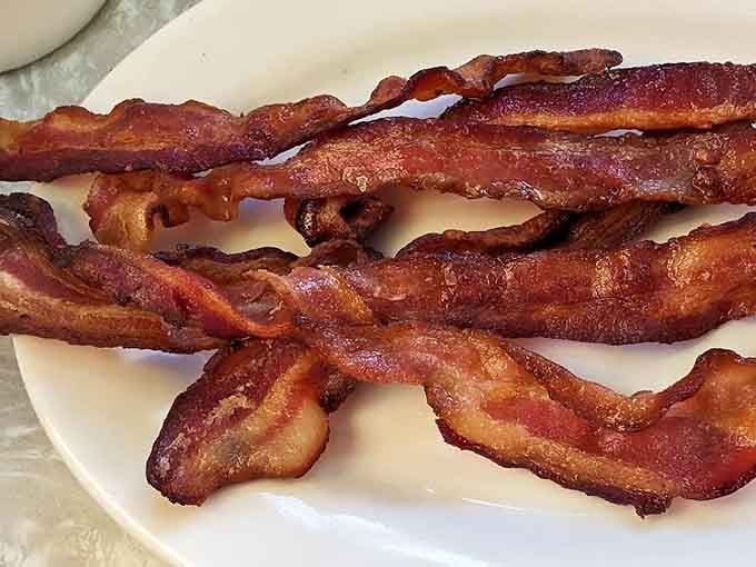 Bacon cooked to crispy perfection, the kind that shatters satisfyingly with each bite like delicious breakfast glass.