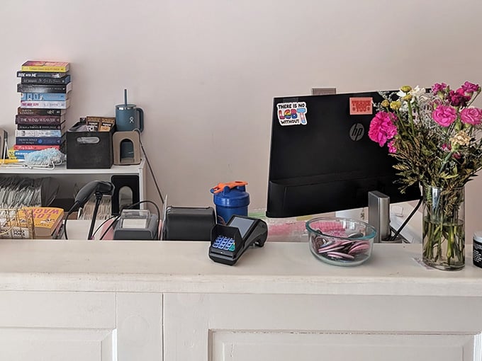 The checkout counter with fresh flowers and stacked books feels more like a friend's desk than a register.