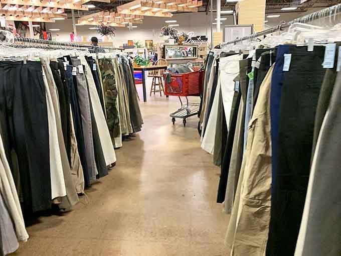 Pants organized by size because even thrift stores understand that nobody enjoys hunting through complete chaos forever.