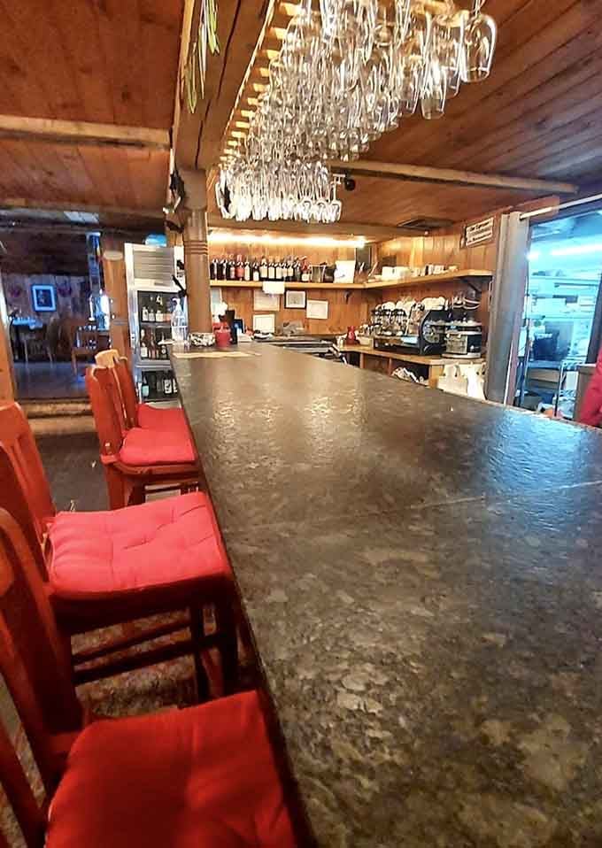 The bar features a stunning chandelier made of wine glasses, because even functional spaces deserve a touch of sparkle.