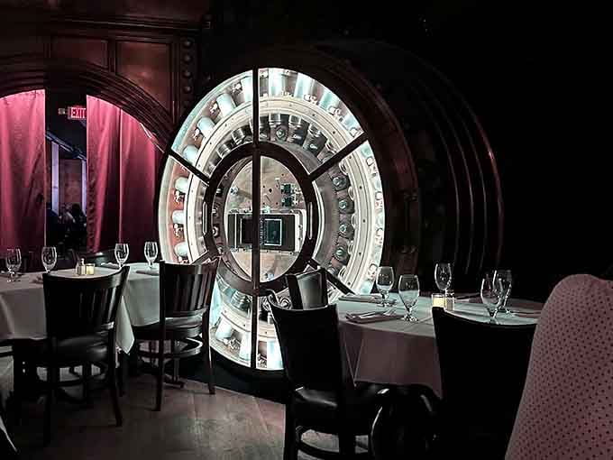 Safety deposit boxes frame the illuminated vault door like a portal to another era of elegance and intrigue.