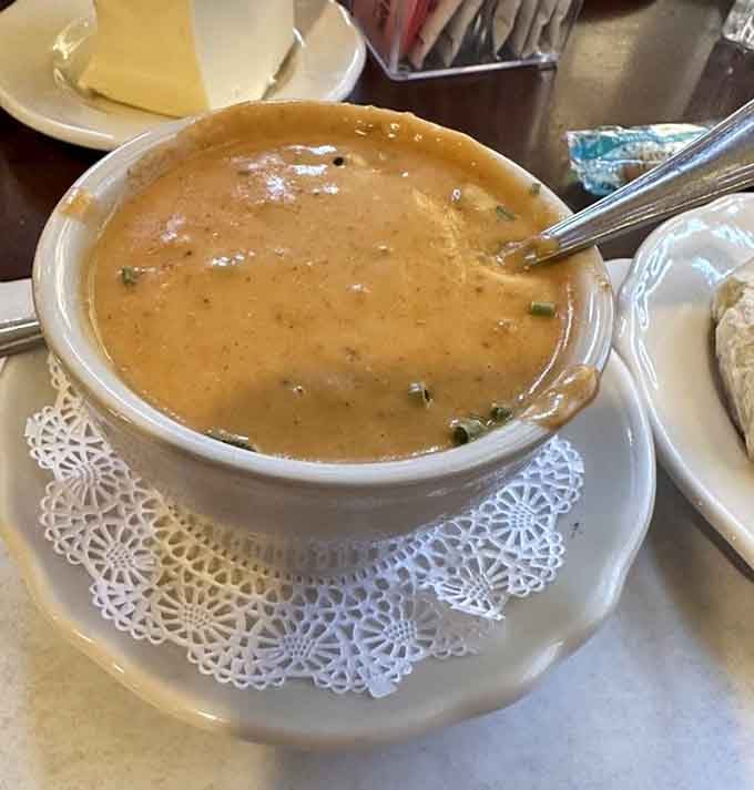 Cream of lobster soup served on a delicate doily, because even comfort food deserves a touch of elegance now and then.