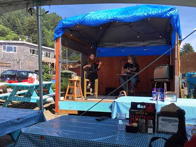 Live music under a blue canopy turns a great meal into a full coastal experience worth planning your trip around.