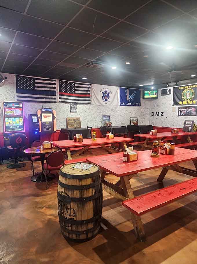 Red picnic tables under military flags—because eating great barbecue is patriotic duty in these parts. That barrel knows what's up.