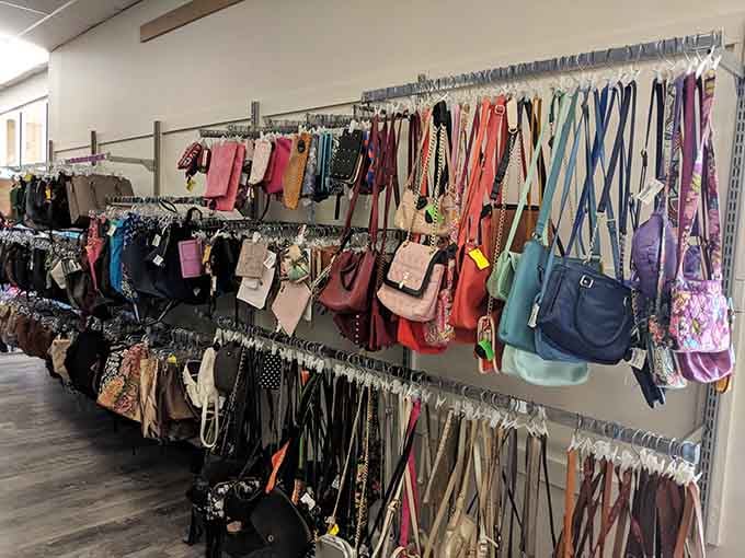 A rainbow of handbags lines the wall at Plato's Closet, where fashion-conscious shoppers can find designer accessories without breaking the bank.