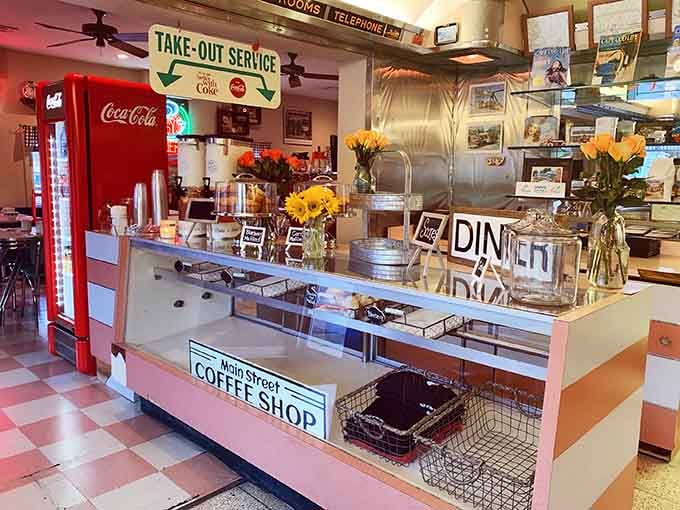 The counter area gleams with vintage Coca-Cola charm and fresh flowers, because even diners deserve a little everyday elegance and beauty.