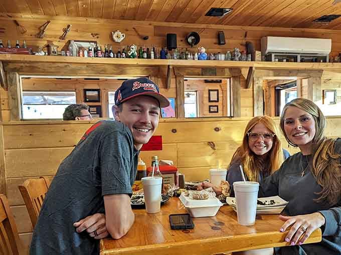 Happy diners around wooden tables prove that great barbecue brings people together better than anything else could.