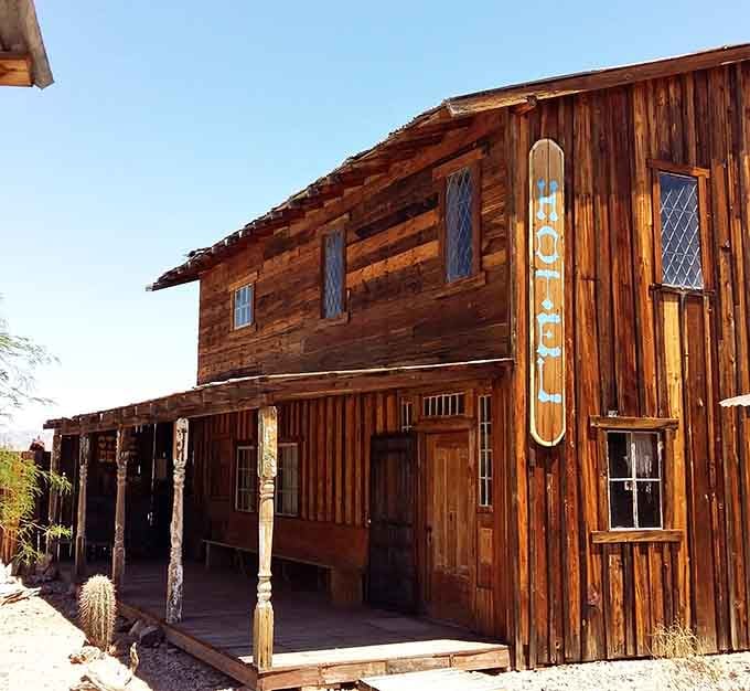 The hotel sign glows warmly, advertising accommodations that once meant luxury in this rugged, unforgiving landscape.