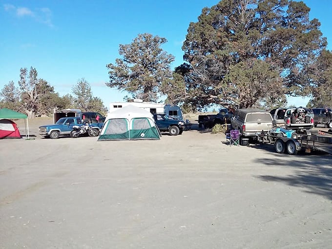 The bustling campground fills with tents, RVs, and trailers as off-road enthusiasts gather for weekend adventures.
