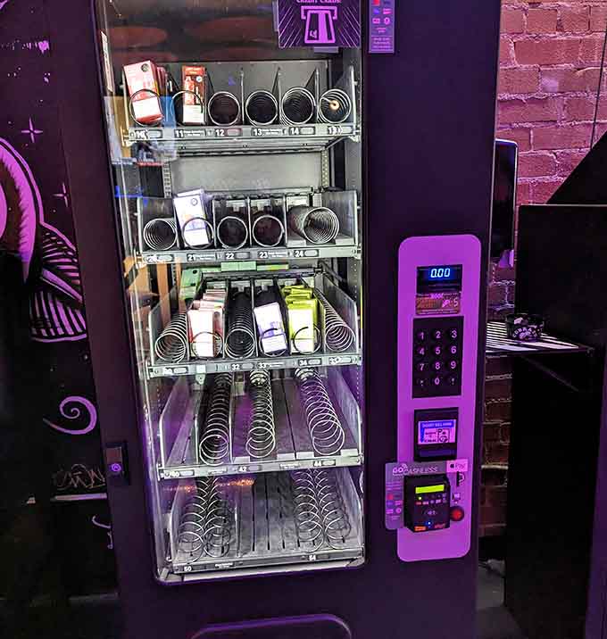 Even the vending machine gets the purple lighting treatment because commitment to atmosphere matters at every level here.
