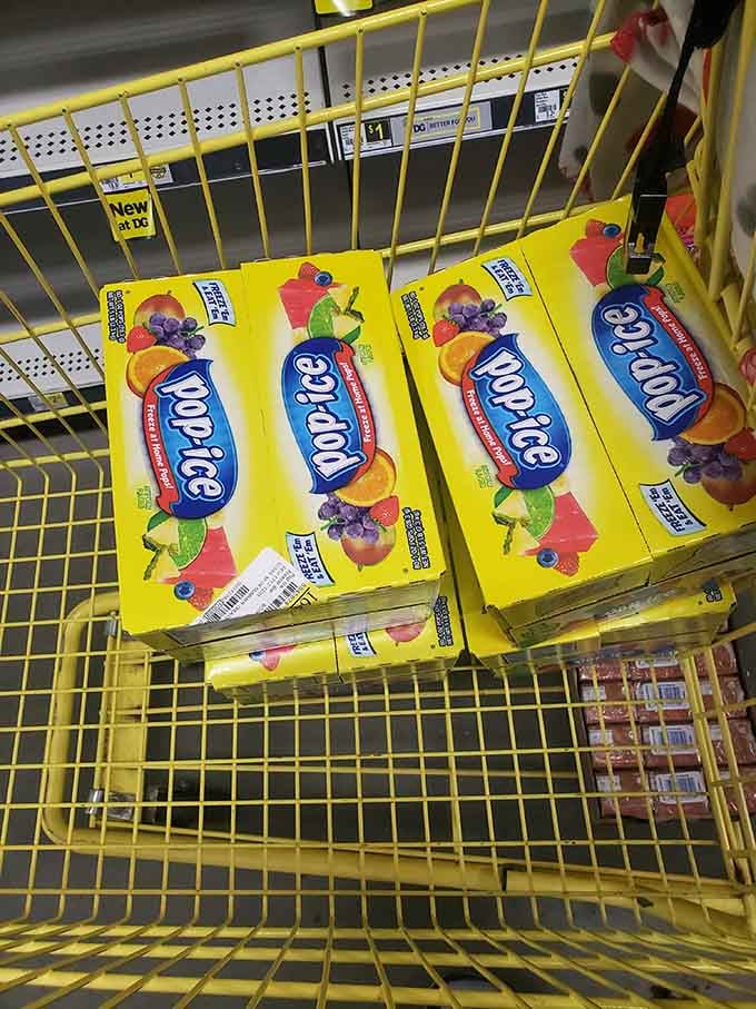 Pop-ice boxes stacked in yellow carts, summer's frozen salvation for kids and adults who refuse maturity completely.