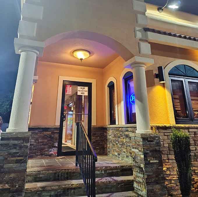 The illuminated entrance with columns and archways at night looks more resort than roadside, setting expectations appropriately high.