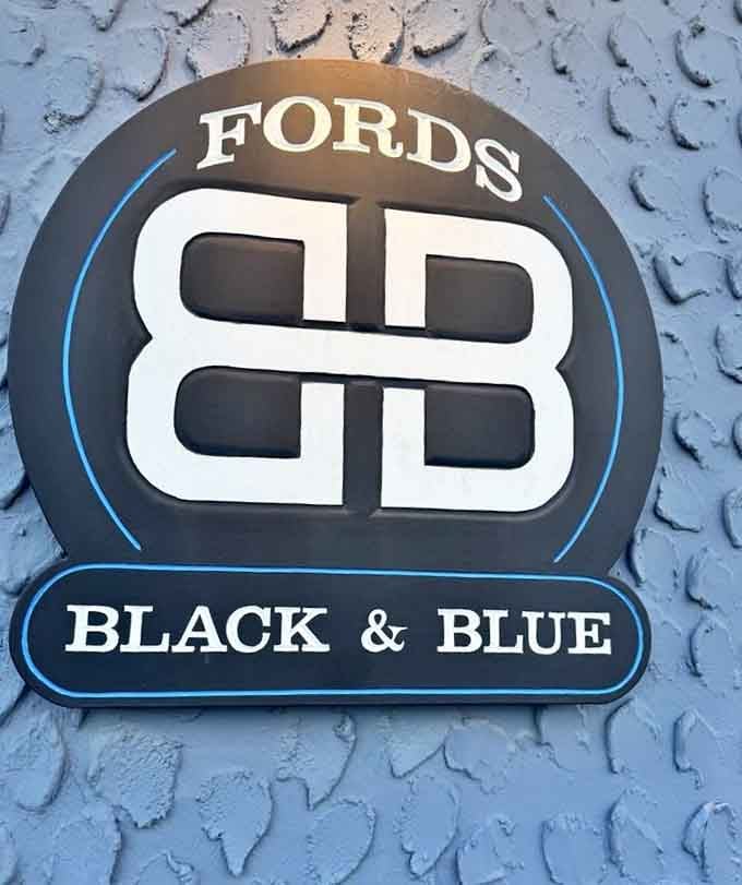 The Ford's Black & Blue logo stands proud against textured siding, marking your destination for unforgettable coastal cuisine.