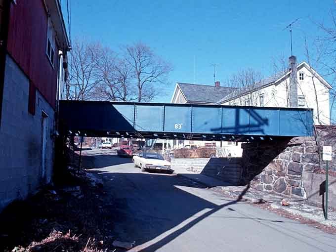 That blue steel bridge cuts across the scene like industrial art, connecting one side of town to the other.