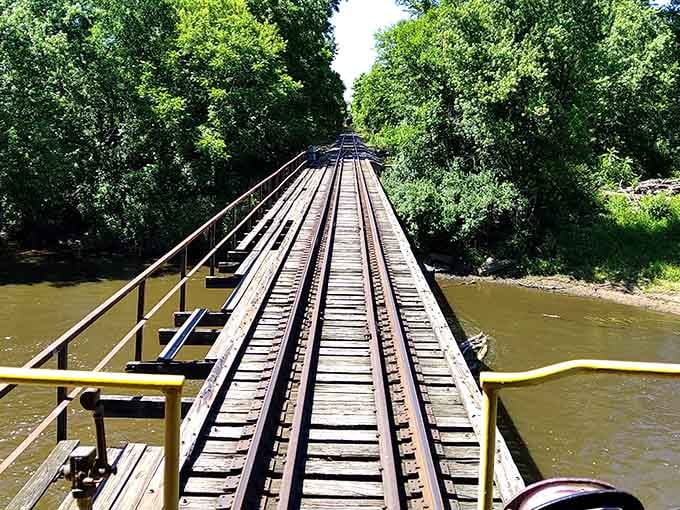 The wooden trestle bridge stretches across the water, a testament to engineering that connected communities long before interstate highways.
