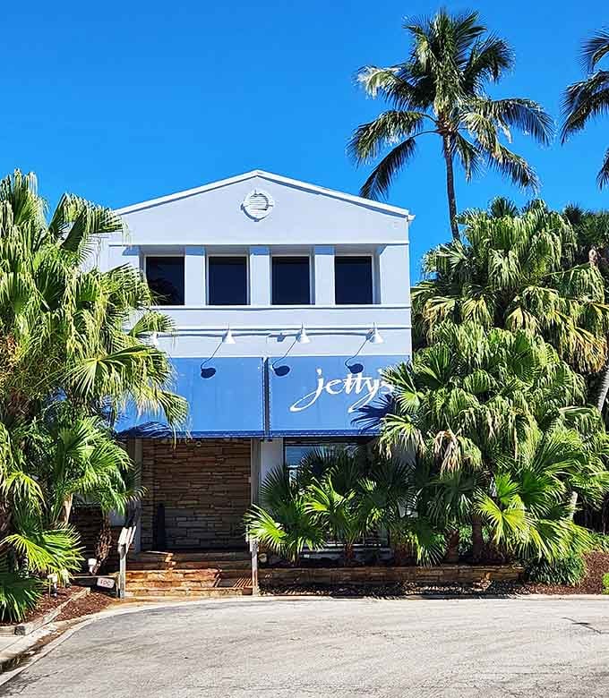 Blue and white exterior framed by tropical landscaping that screams Florida without saying a single word.