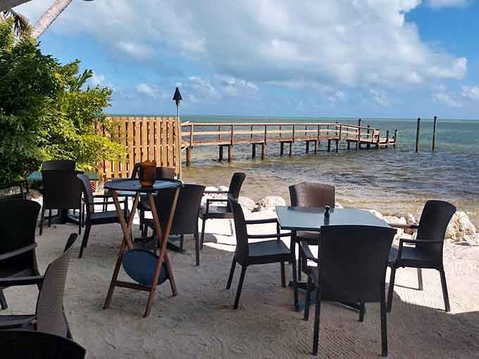Waterfront patio seating where gentle breezes and lapping waves provide the soundtrack to your perfectly relaxed island meal.
