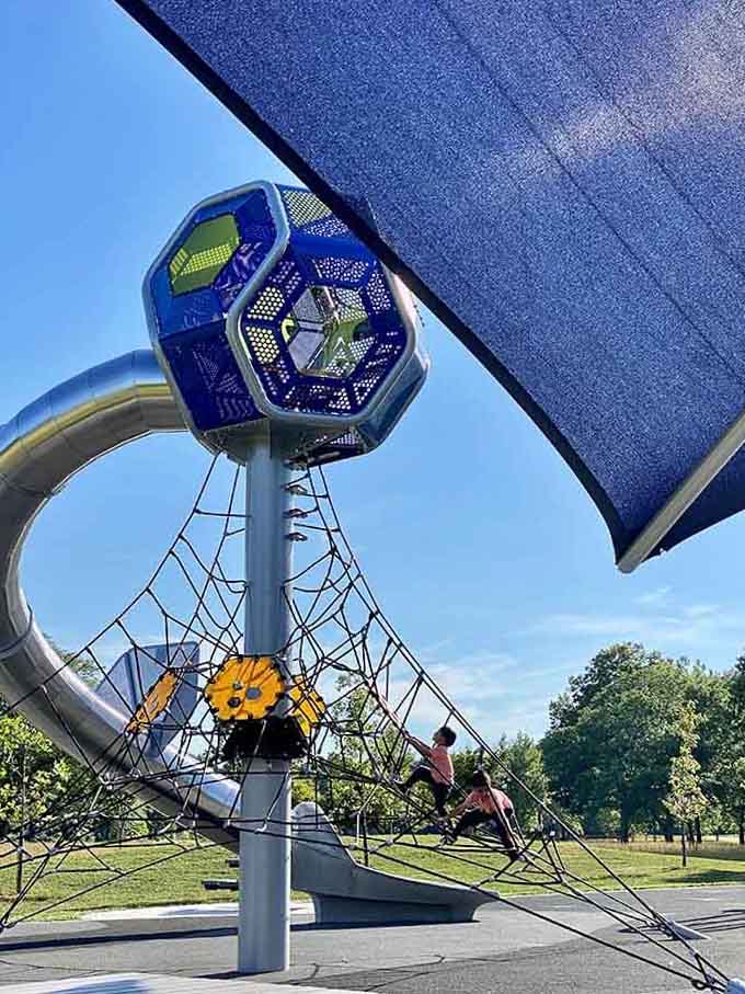 The climbing tower with its intricate rope network challenges kids to reach new heights while building strength and courage.