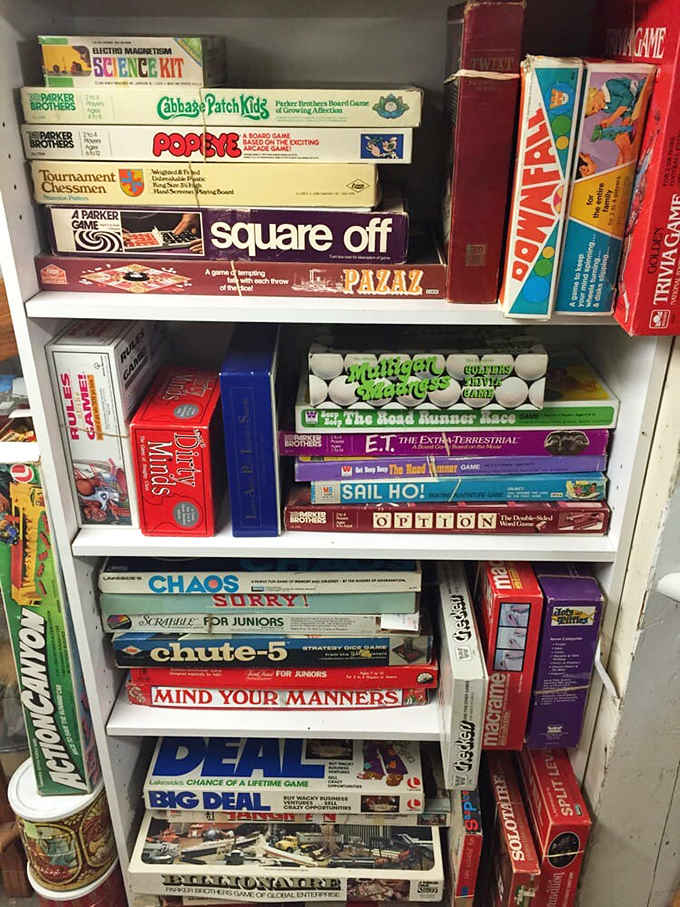 Board games stacked like a tower of childhood memories when family game night didn't require WiFi or charging cables, just patience.