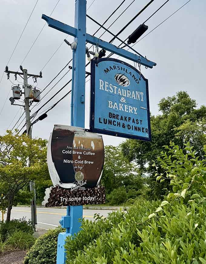 That blue sign announcing breakfast, lunch, and dinner has been guiding hungry travelers to happiness for longer than most restaurants have existed.
