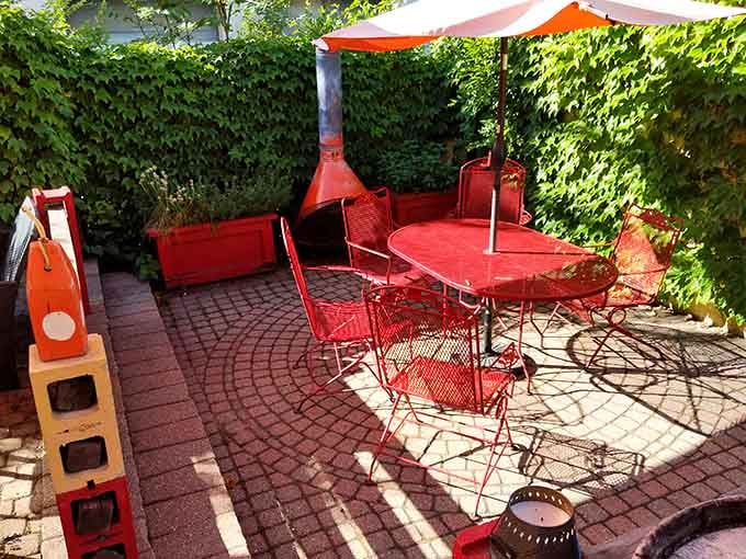 Red patio furniture surrounded by ivy creates the perfect spot for contemplating your excellent life choices.