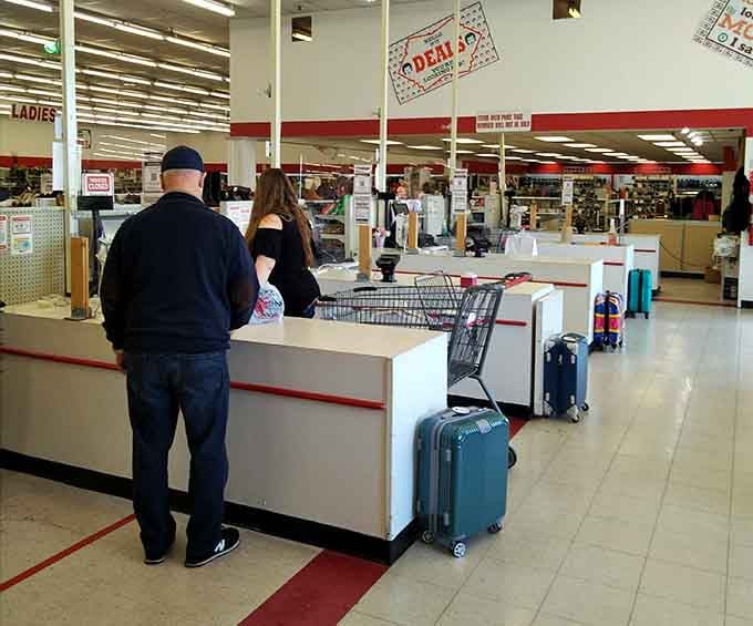 Shoppers queue at checkout with their treasures, suitcases in tow like they're heading somewhere fabulous.