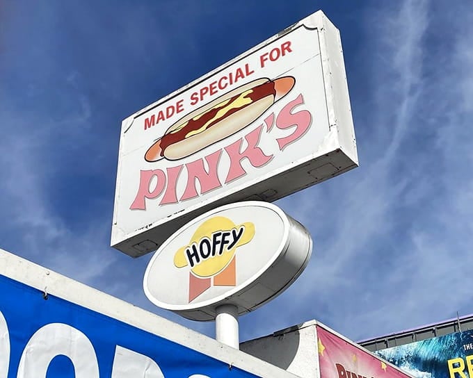 That vintage signage has been guiding hungry pilgrims to hot dog paradise for longer than most restaurants survive.