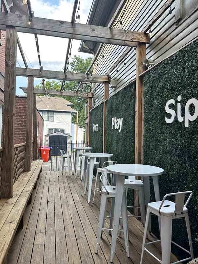 Outdoor seating with "Purr, Play, Sip" on the wall, because someone finally understands the perfect afternoon activity list.