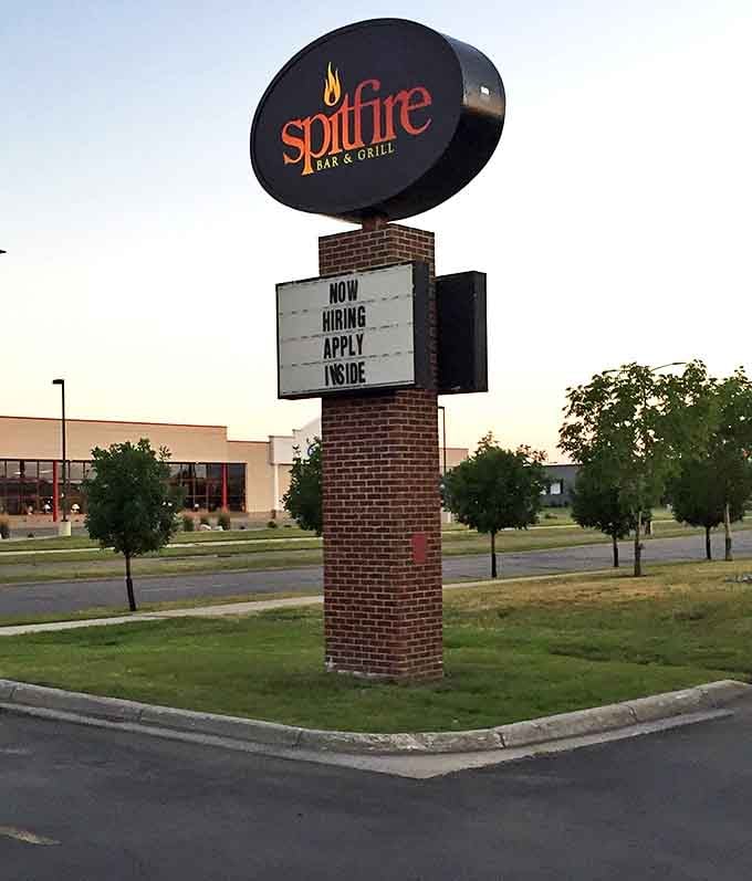 Spitfire's roadside sign stands like a barbecue lighthouse, guiding hungry travelers to their smoky salvation.