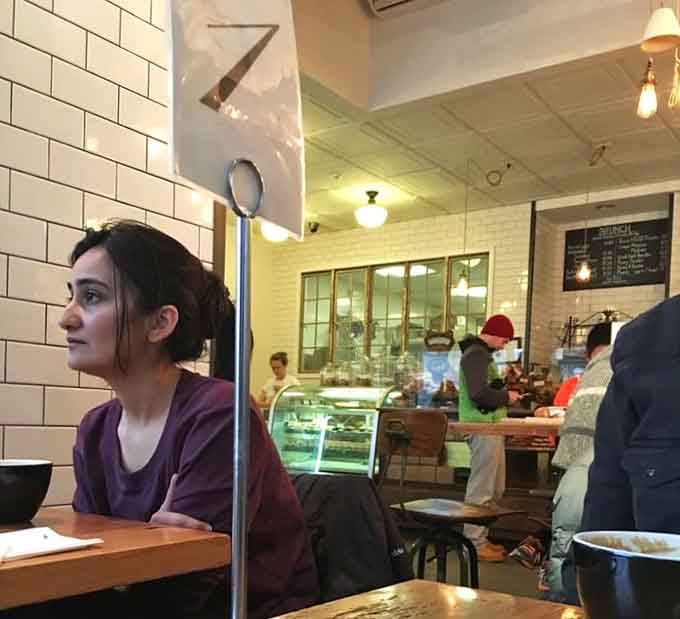 The buzz of conversation and clinking cups fills this bright space where breakfast becomes a leisurely social event.