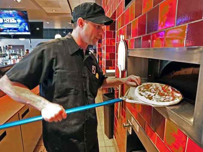 Fresh pizza emerging from the oven, because this tavern does more than just breakfast when hunger strikes later.