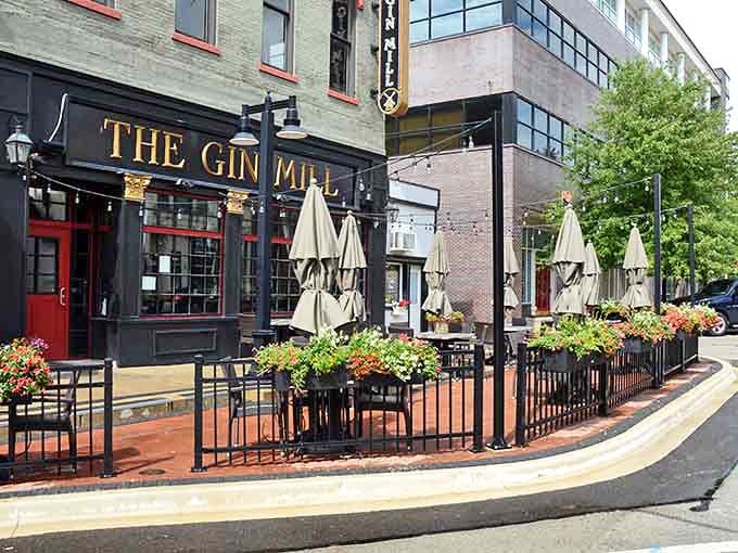 The Gin Mill's inviting patio beckons with urban charm and flowerpots bursting with color. Those empty chairs are practically begging for friends to gather.