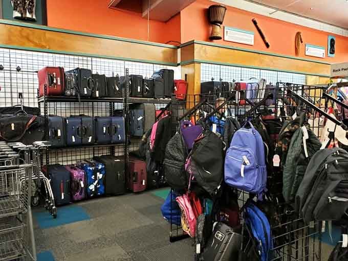 Backpacks and luggage stacked high in delicious irony, selling the very thing people lost to get here.