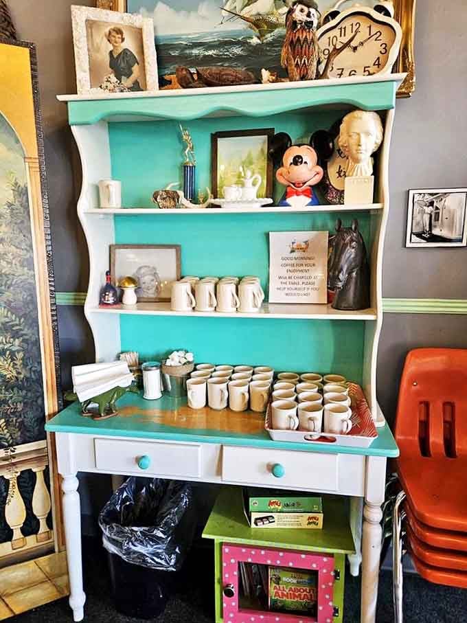 This turquoise hutch isn't just storage &ndash; it's a character in the restaurant's story, holding mugs ready for coffee adventures.