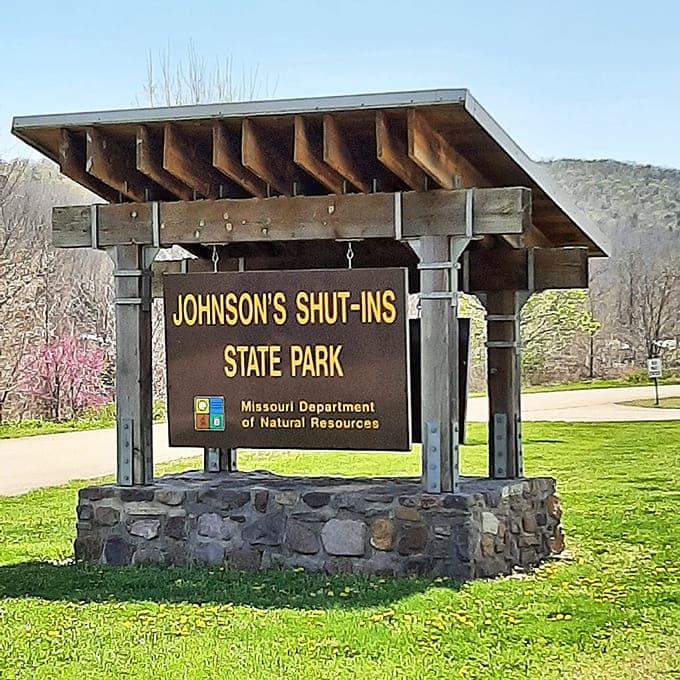 The park entrance sign stands as a humble gatekeeper to extraordinary beauty, like finding a treasure map in your grandmother's attic.