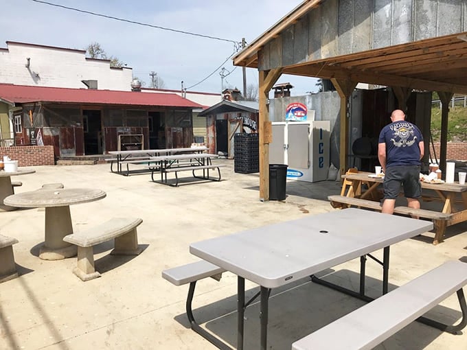 The outdoor seating area &ndash; where summer breezes carry smoke signals that whisper, "Come eat something amazing." Simple picnic tables promise unfussy, extraordinary meals.