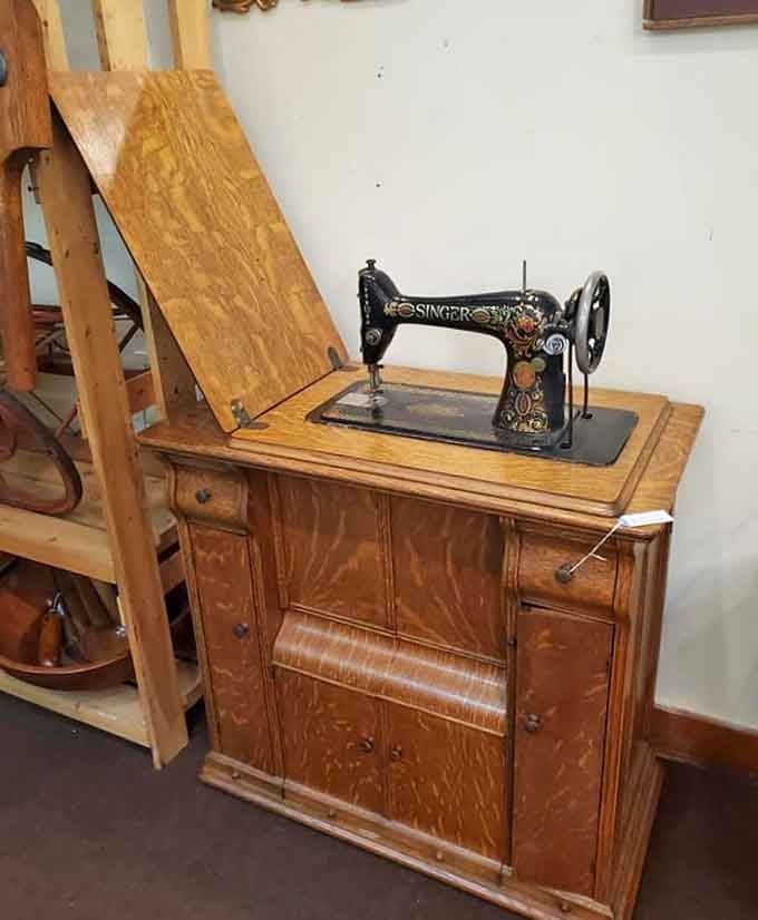 A Singer treadle sewing machine in its original cabinet, representing an era when people actually repaired their clothes.