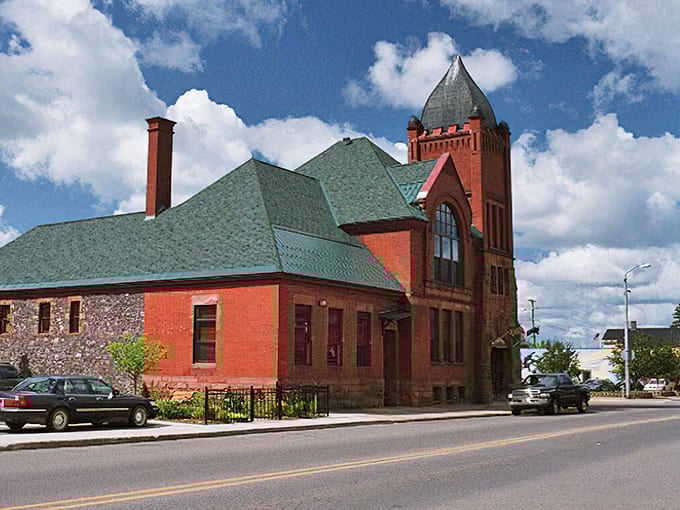 This grand brick building with its tower and green roof commands respect, standing as a monument to architectural pride.