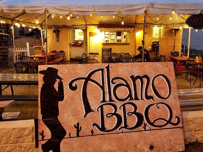 That hand-painted sign glowing at dusk promises exactly what it delivers: authentic barbecue worth the inevitable line and wait.
